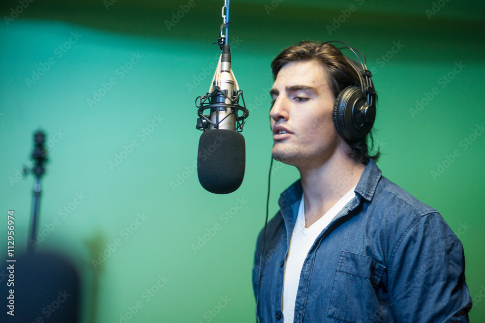 Male musician in recording studio, singing into microphone Stock Photo ...