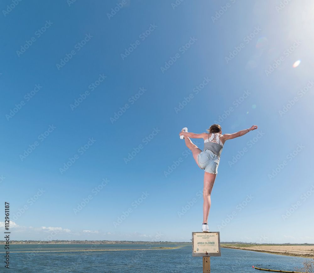 Girl balancing on beach signage Stock Photo | Adobe Stock
