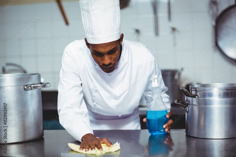 Foto Stock Chef cleaning kitchen counter | Adobe Stock