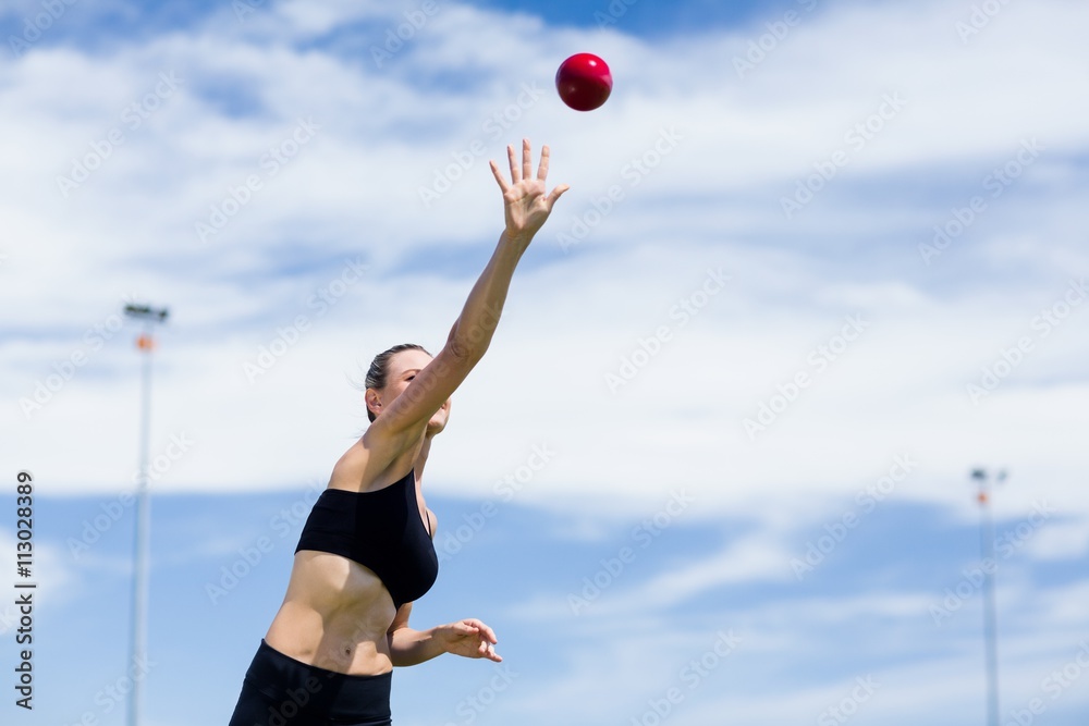 Confident female athlete throwing shot put ball Stock Photo | Adobe Stock