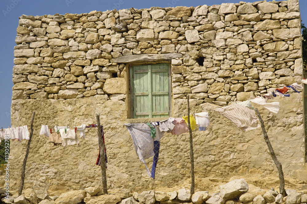 Washing line in front of an old stone wall with small window at Kastri ...