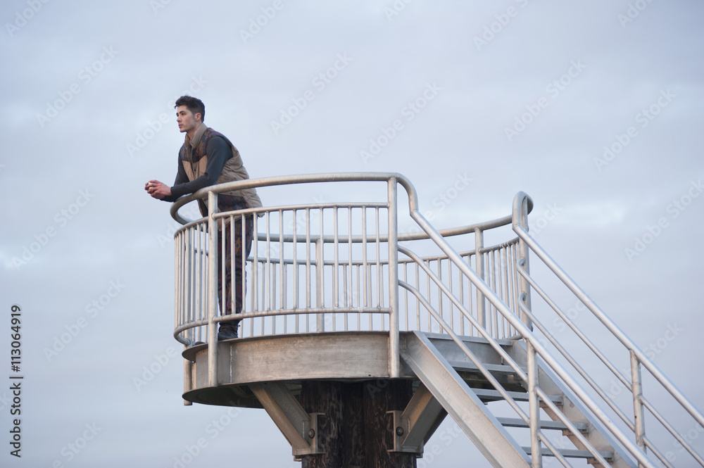 Full length of thoughtful man leaning on railing at tower Stock Photo ...