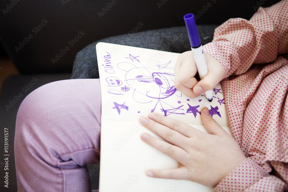 Mid-section of girl drawing with felt tip pen Stock Photo | Adobe Stock