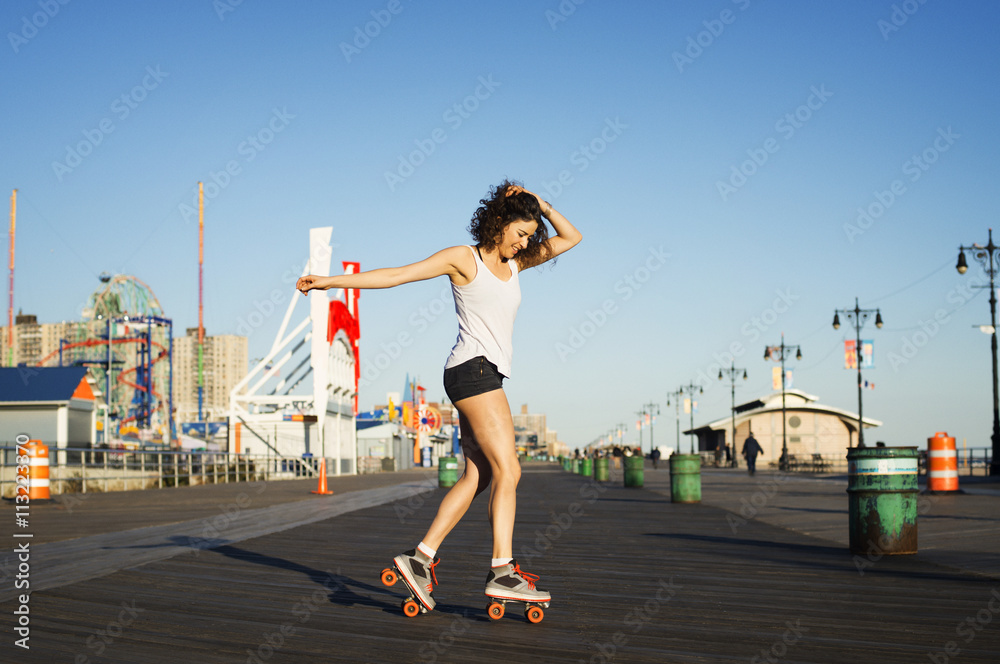 Young woman roller skating on road Stock Photo | Adobe Stock