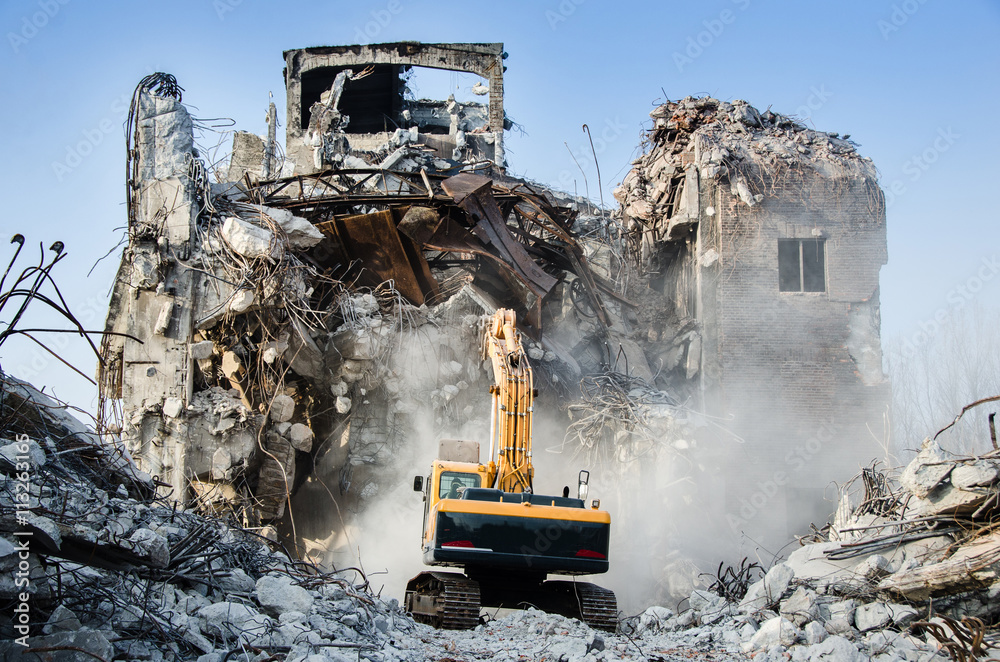 Excavator working at the demolition of an old industrial buildin Stock ...