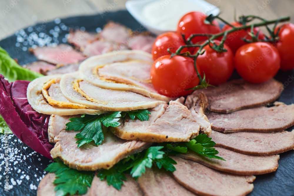 Cold cuts of roast beef, baked ham, chicken roll and beef tongue served ...