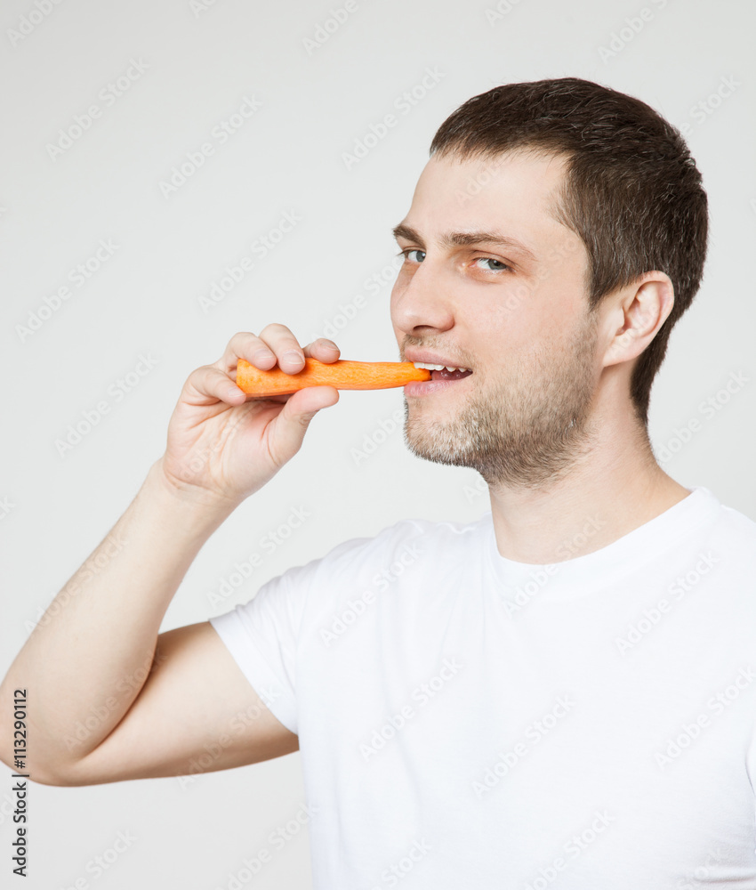 Happy young man eating a carrot Stock Photo | Adobe Stock