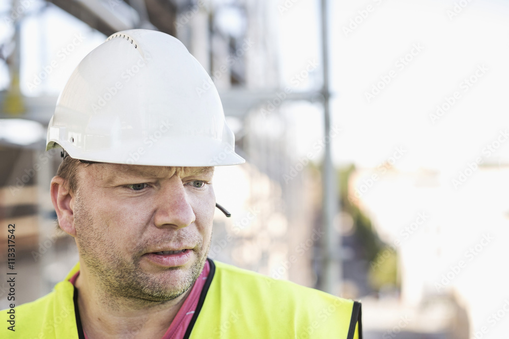 Construction worker wearing hardhat at construction site Stock Photo ...