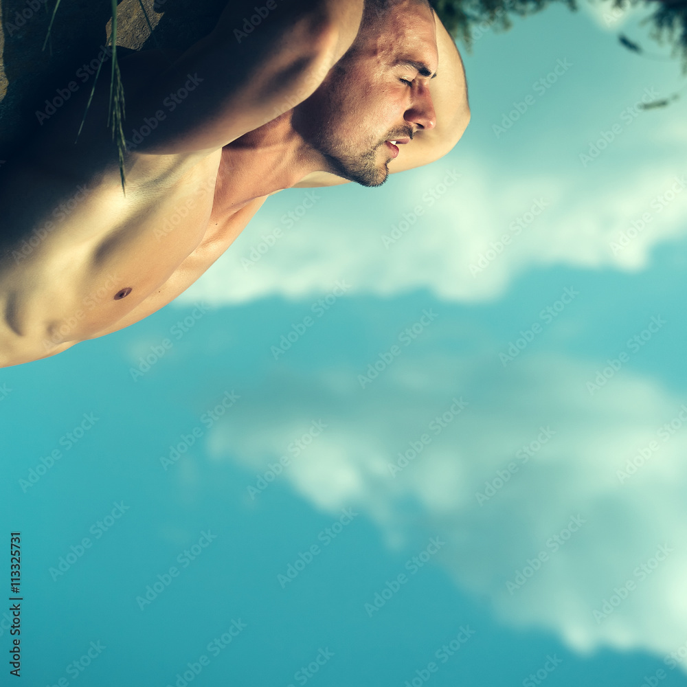 muscular man relaxing on sky backdrop Stock Photo | Adobe Stock
