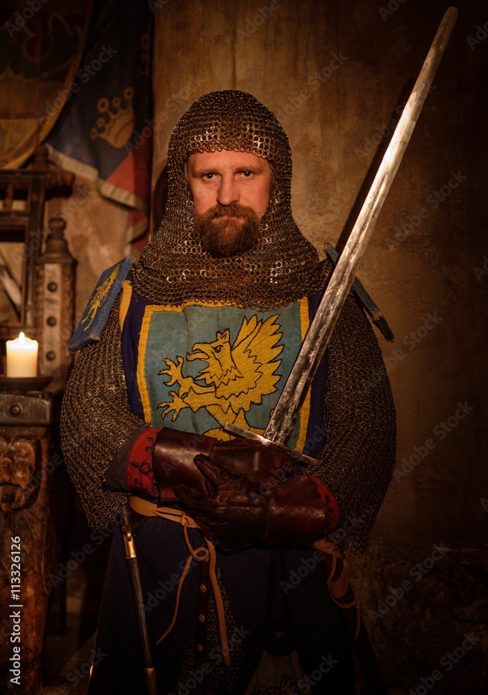 Medieval knight on guard in ancient castle interior. Stock Photo ...