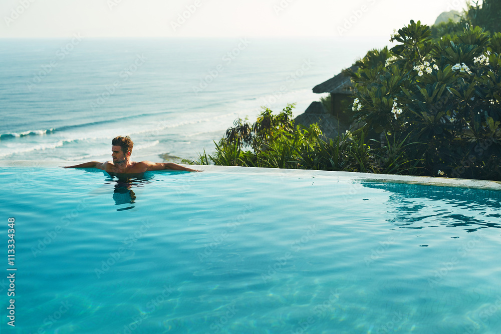 Luxury Resort. Man Relaxing In Infinity Swimming Pool Water. Beautiful ...