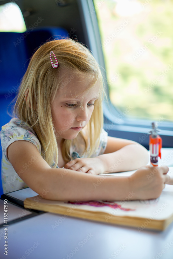 Girl drawing pictures while sitting on train's seat Stock Photo | Adobe ...