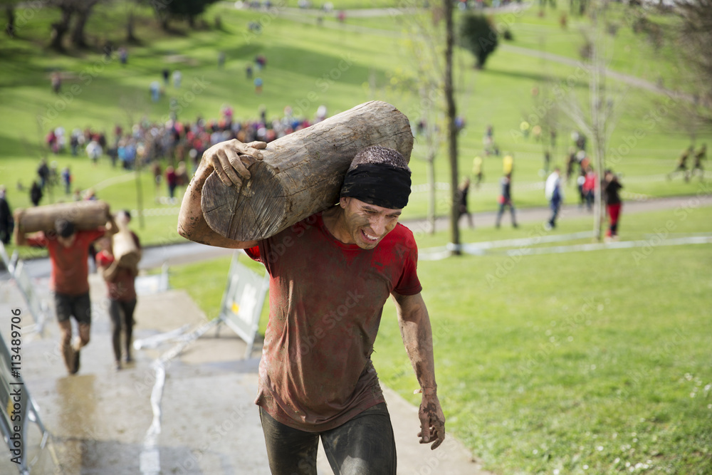 Man carrying log and climbing steps foto de Stock | Adobe Stock