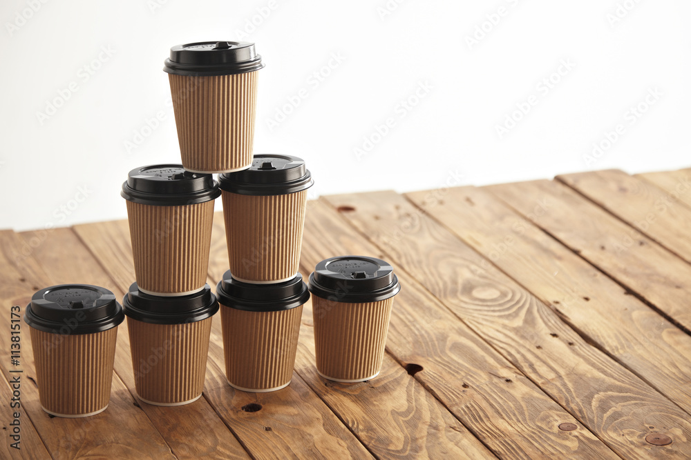 Brown cardboard take away paper cups with black caps in pyramid house ...