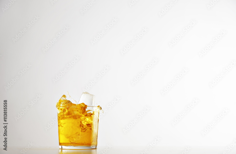 Splash cocktail drink inside transparent glass with ice cubes isolated ...