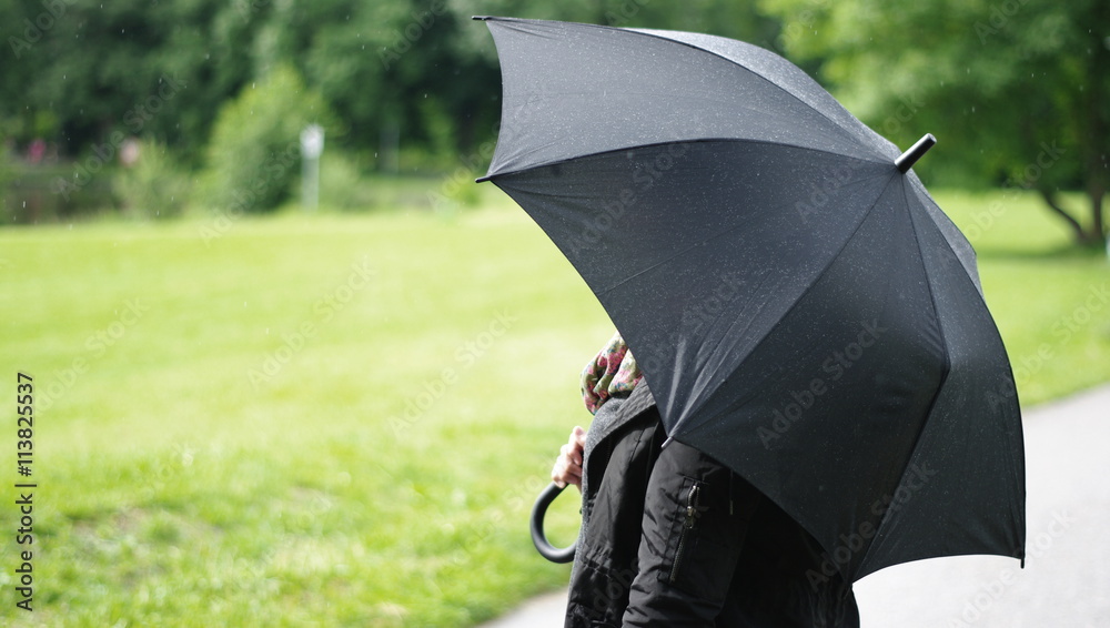 Frau mit Schirm im Regen Stock-Foto | Adobe Stock