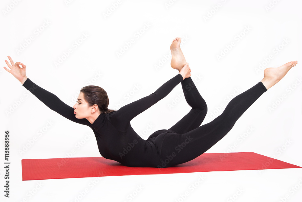 Beautiful athletic girl in a black suit doing yoga. Supta Virasana ...