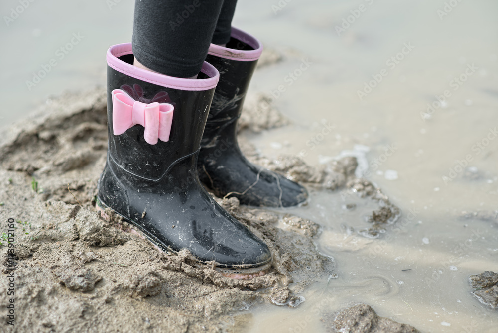 Child rubber boots and puddle. Stock Photo | Adobe Stock