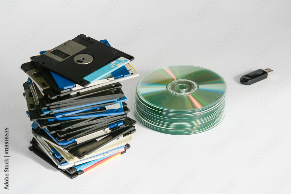 Pile of floppy disks, cd-roms, external hard drive and pen over white ...