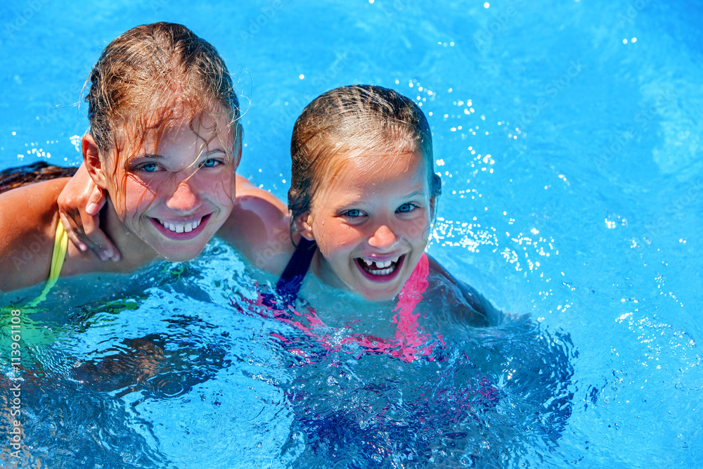 Two different ages children hugging and looking up swim in swimming ...