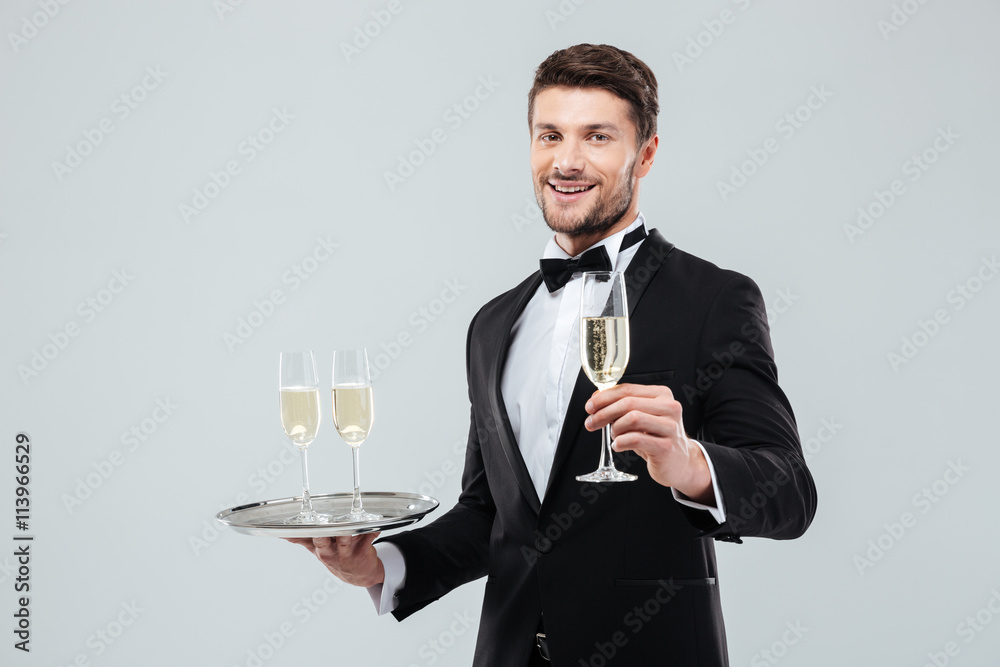 Happy butler in tuxedo holding tray and glass of champagne Stock Photo ...