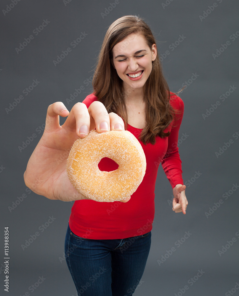 Photo & Art Print giggling young woman grabbing a donut as junk food ...