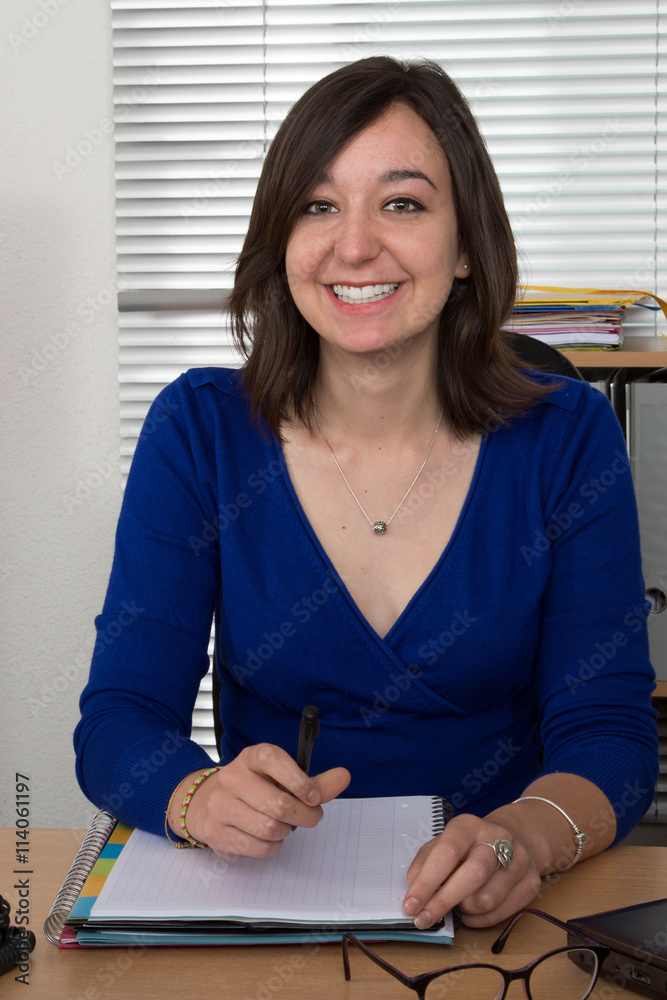 Portrait of a pretty secretary sitting at her desk and smiling Stock ...