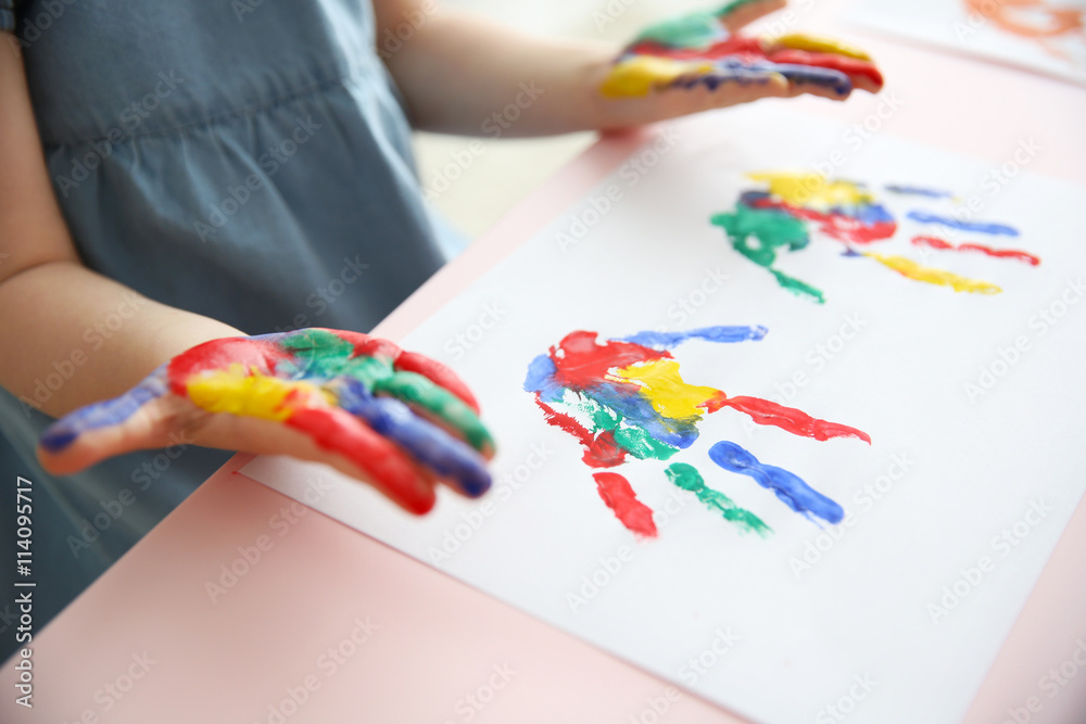 Child making hand prints on paper Stock Photo | Adobe Stock