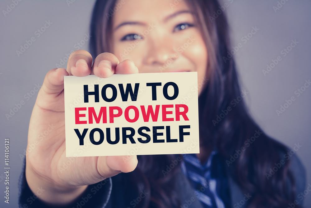 HOW TO EMPOWER YOURSELF message on the card shown by a businesswoman ...