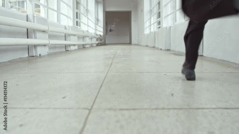 Low angle view of school boys and girls running through corridor in ...