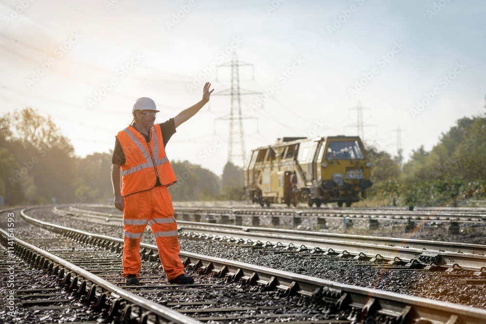 Rail worker signalling to maintenance train on railway Stock Photo ...