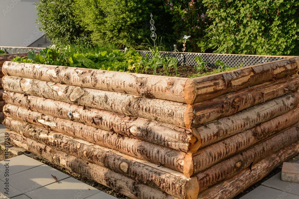 rustikales Hochbeet aus Baumstämmen Stock Photo | Adobe Stock