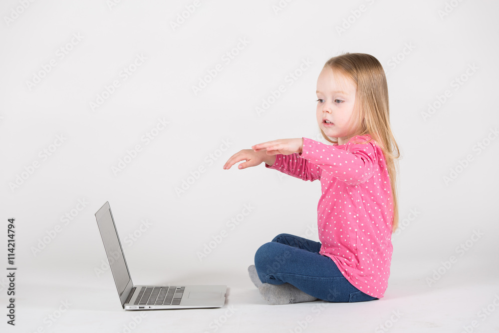 junges Mädchen sitzt seitlich vor Laptop / PC / Computer und ...
