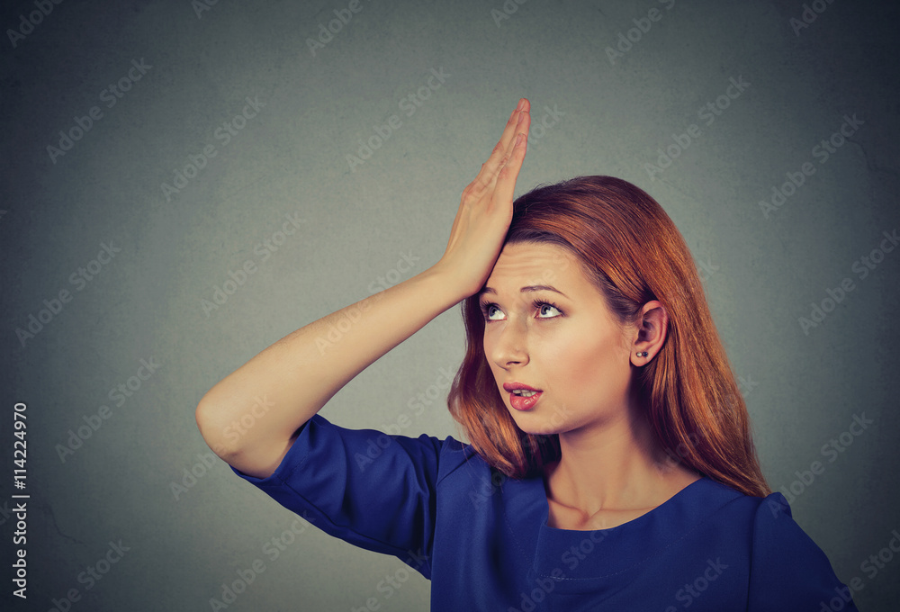 Regrets wrong doing. Silly young woman, slapping hand on head having ...
