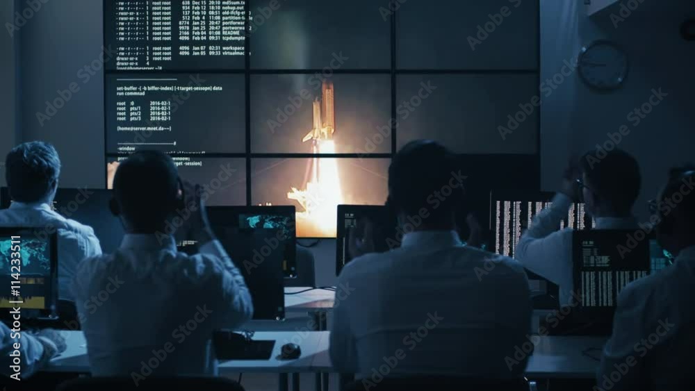 Group of People in Mission Control Center filled with Displays ...
