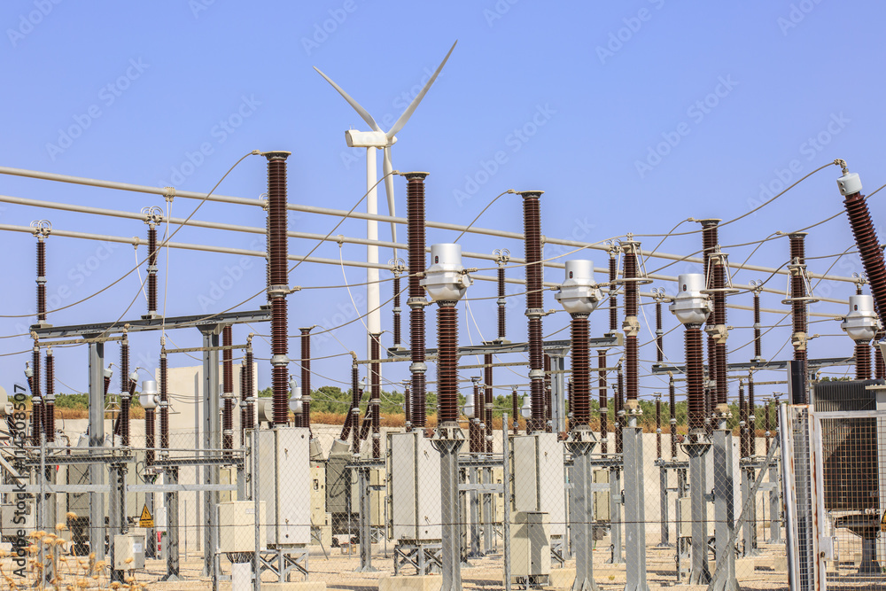 Detail of electrical substation of a wind farm, with a wind turbine at ...