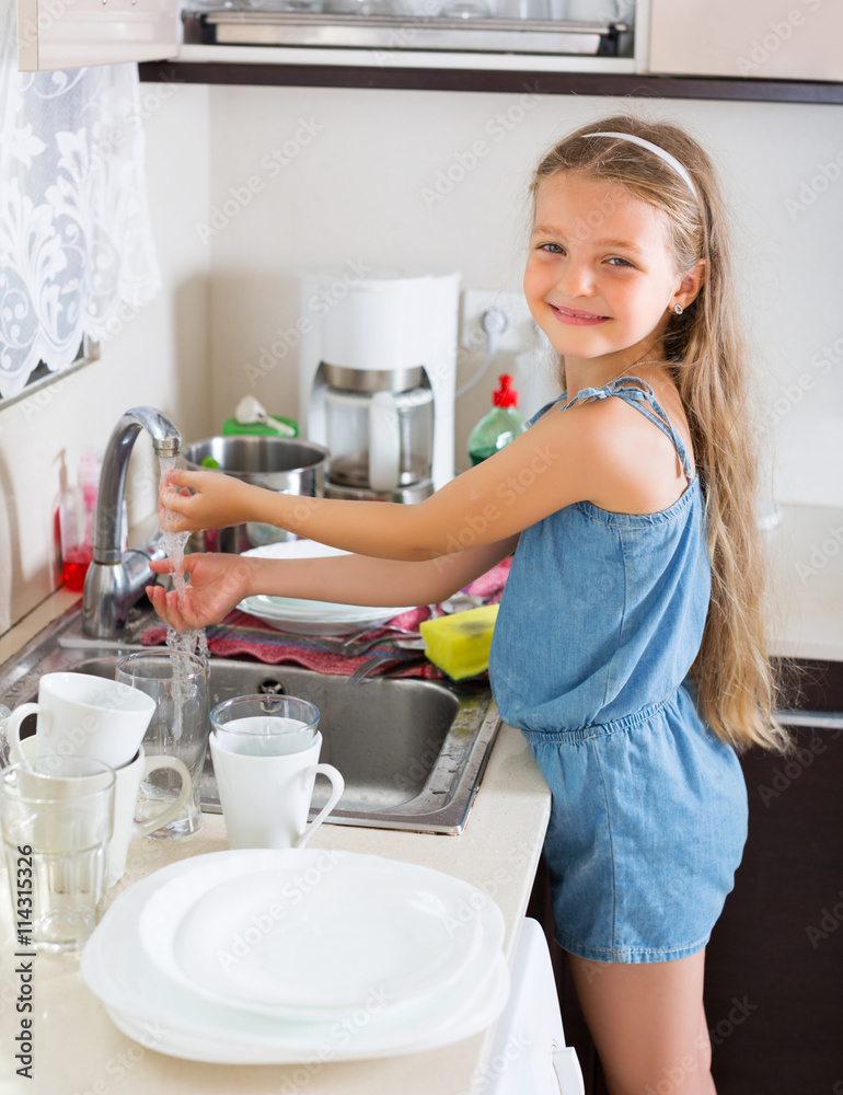 Girl doing dishes at kitchen Stock Photo | Adobe Stock