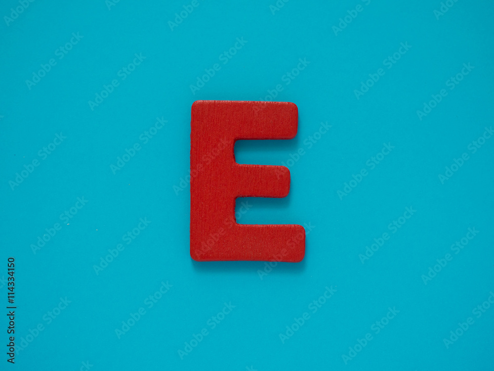Capital letter E. Red letter E from wood on blue background. Alphabet ...