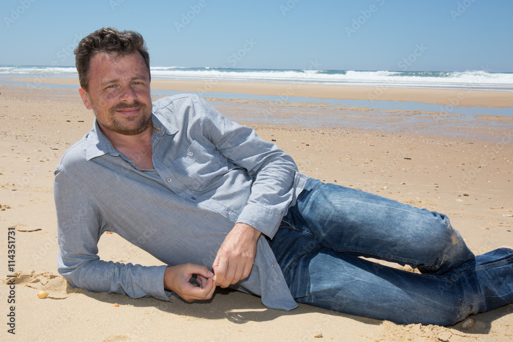 Man lying on the beach Stock Photo | Adobe Stock