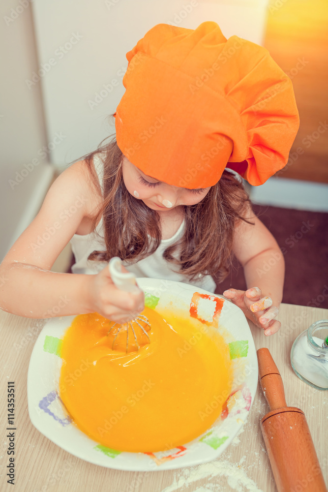 beautiful cute little girl with bonnet making pasta dough in kitchen ...
