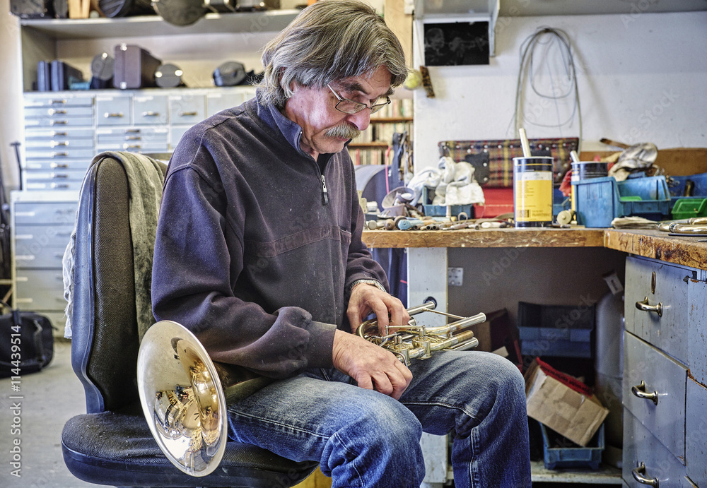 Instrument maker repairing trumpet in workshop Stock-Foto | Adobe Stock