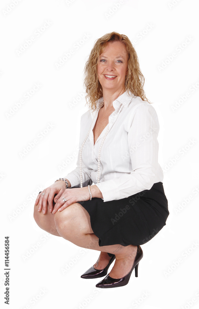 Smiling woman crouching on floor. Stock Photo | Adobe Stock