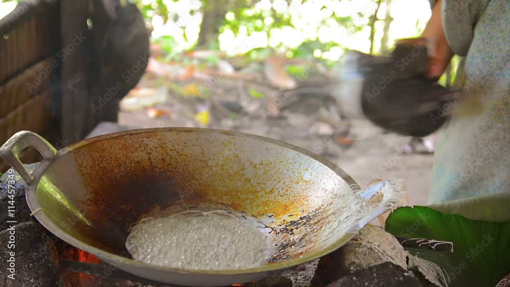 Video 1080p - Woman pouring a sweet, coconut batter into hot oil in a ...