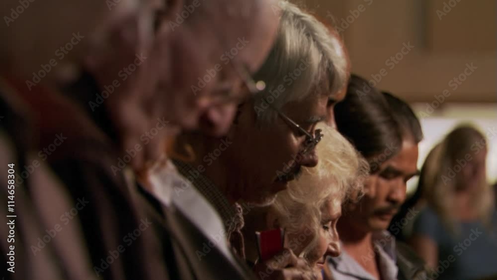 Seated congregation praying with bowed heads Stock Video | Adobe Stock
