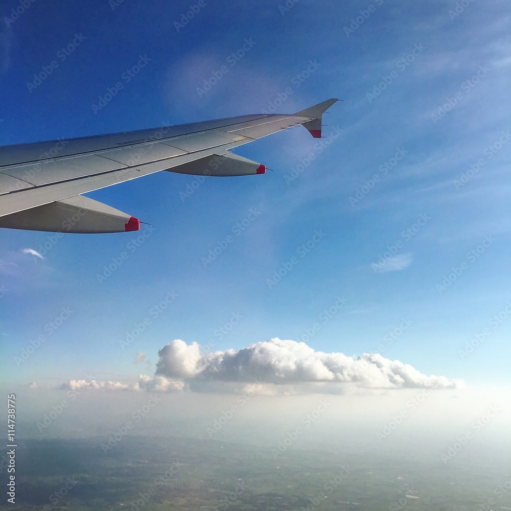 Foto de Grey Airplane wing in a blu sky with a white cloud do Stock ...