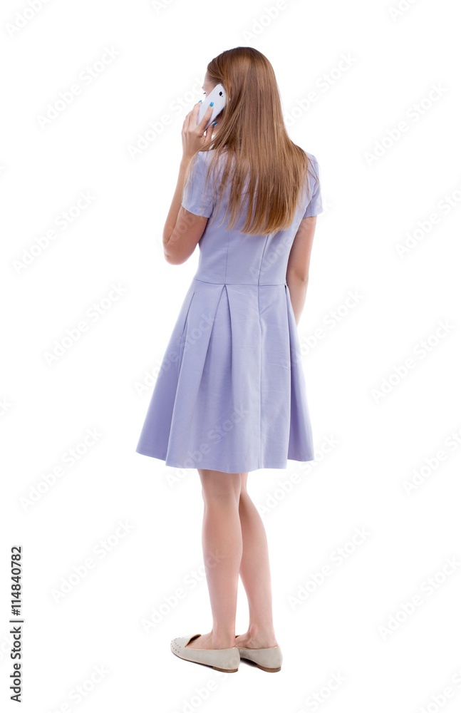 back view of a woman talking on the phone. backside view of person ...