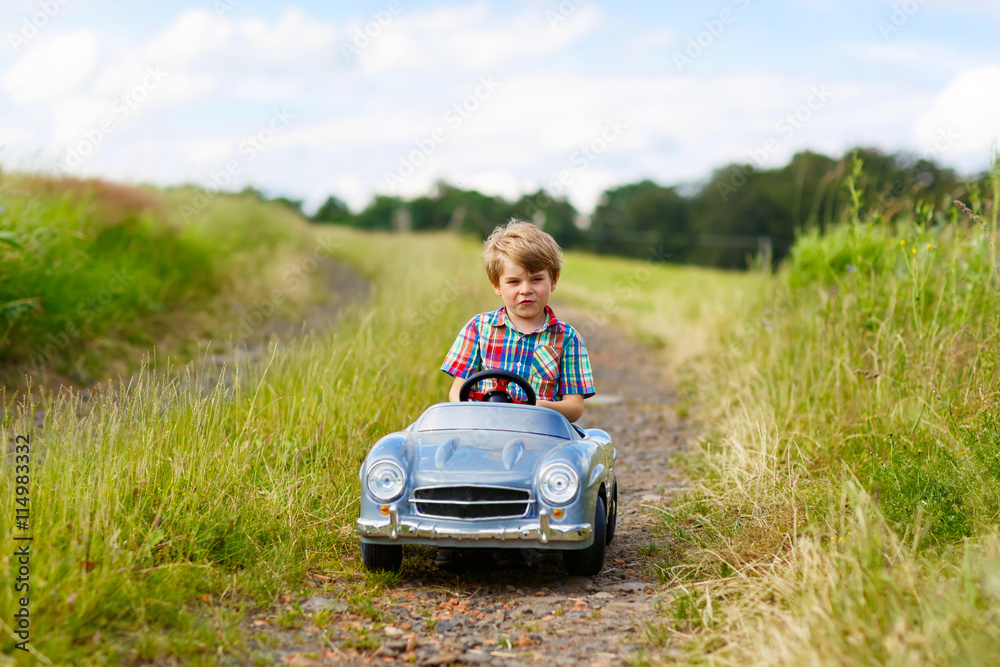 Little kid boy driving big toy car with a bear, outdoors. Stock Photo ...