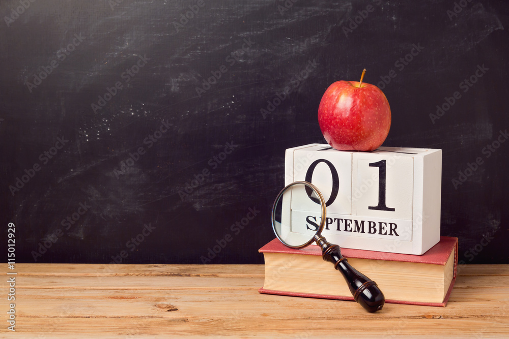 Back to school background with book, apple and calendar over chalkboard ...