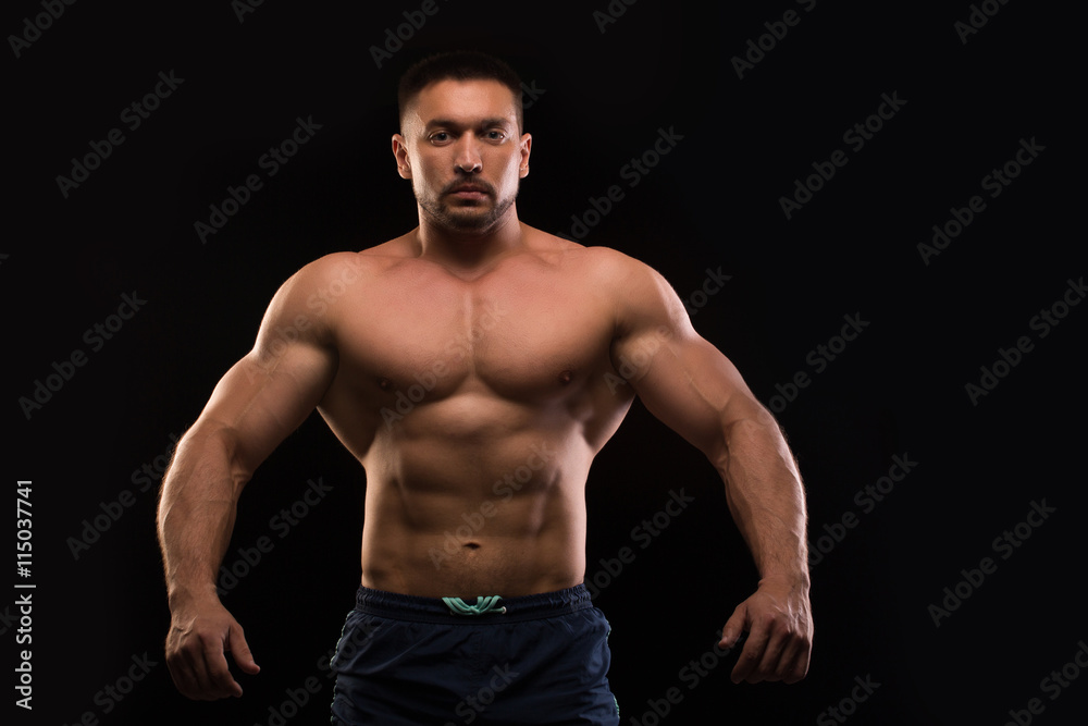 handsome muscular bodybuilder posing on a black background Stock Photo ...
