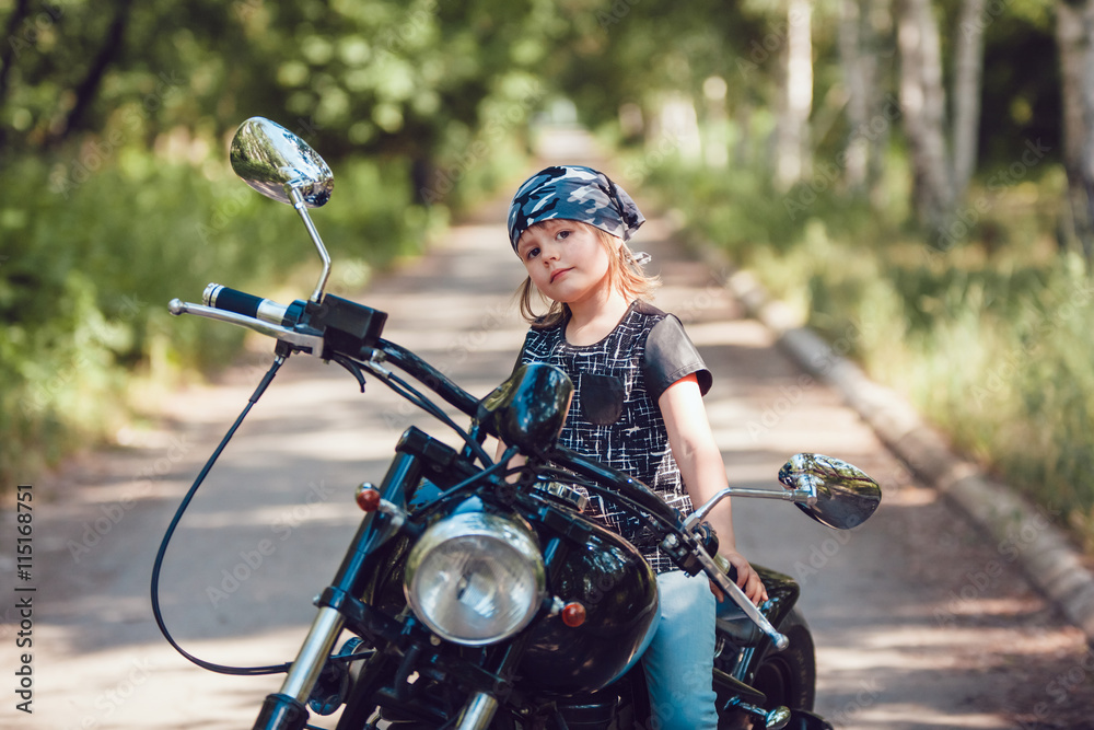 Little girl on a motorcycle. Stock Photo | Adobe Stock